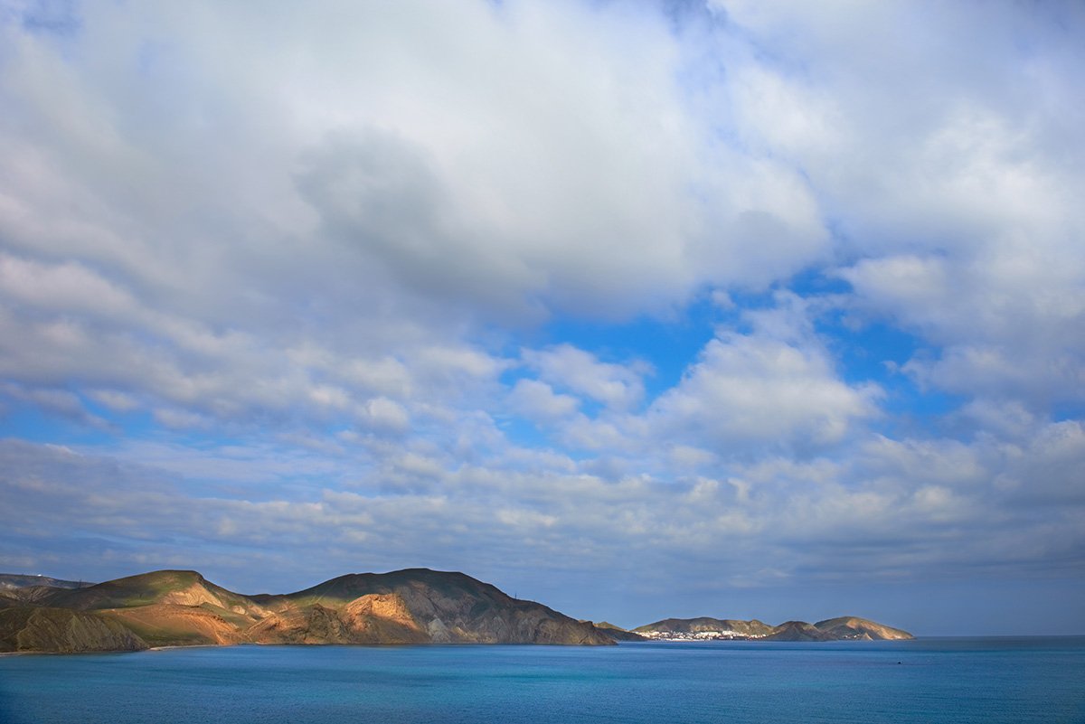 Sea harbor with blue water, islands and blue sky with clouds