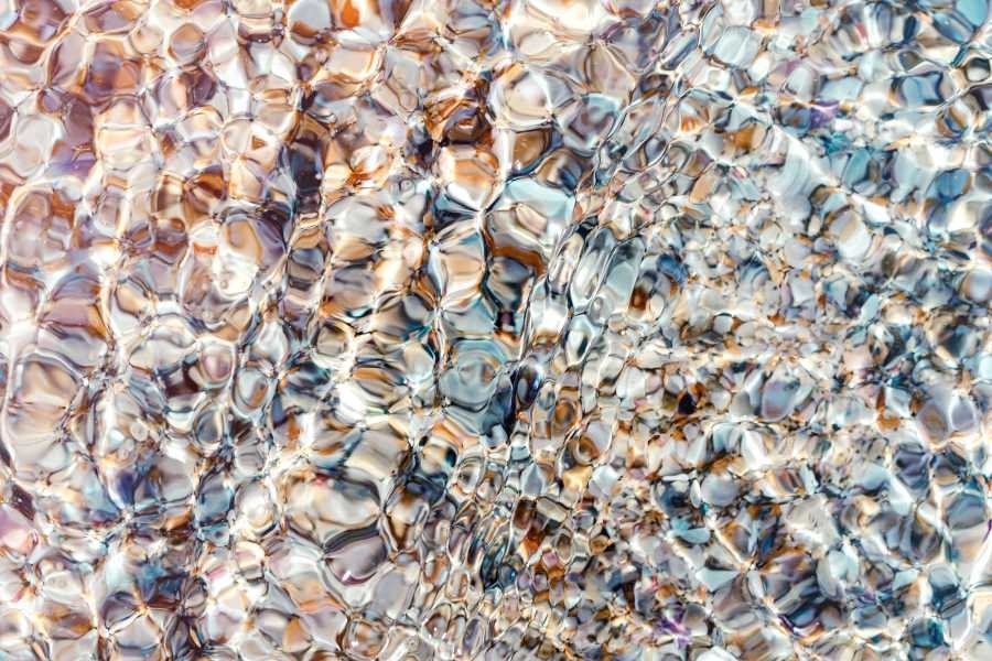 Texture of pebbles through clear glass sea water