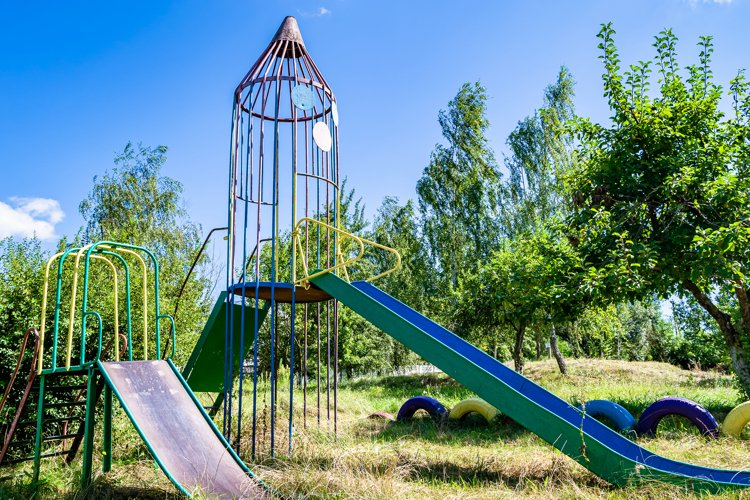 Empty playground with metal slide for kids on nature