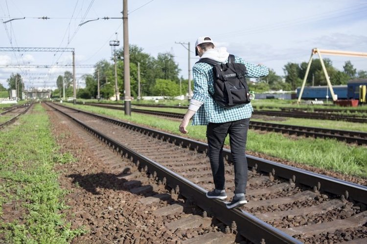 A man walks on the rails of the railway