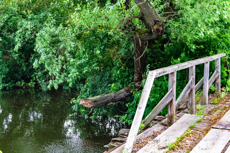 Beautifully standing old wooden bridge over river background