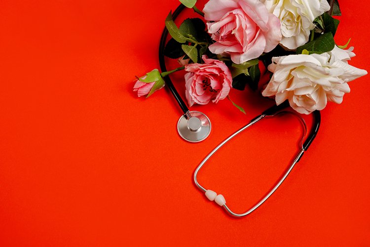 Bunch of rose flowers and stethoscope on bright red