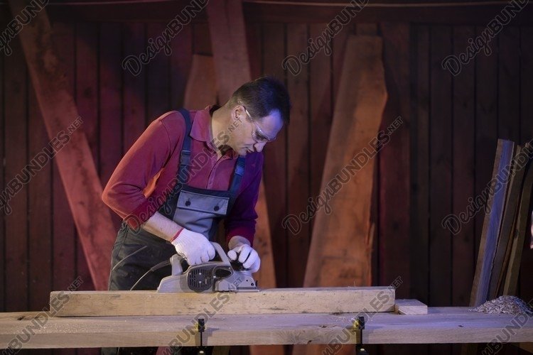 middle-aged male carpenter processes wooden (1006286)