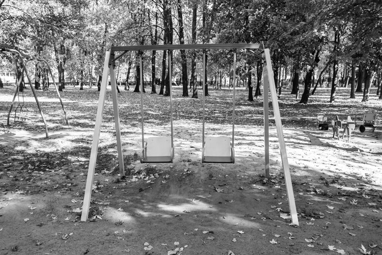 Empty playground with metal swing for kids on nature