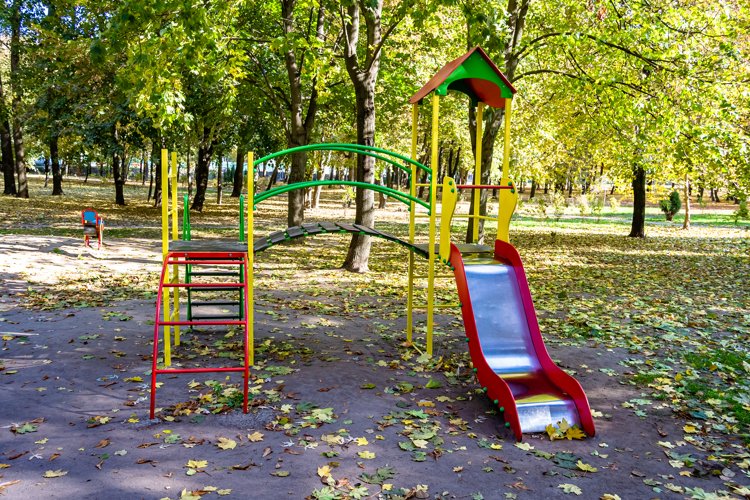 Empty playground with metal slide for kids on nature
