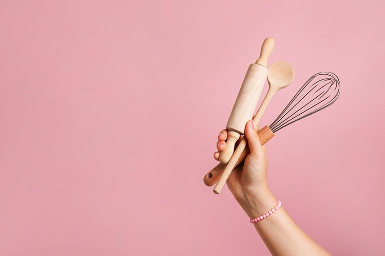 Female hand holding kitchen utensils for food and bakery