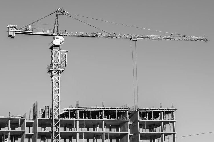 Big steel crane on construction site of residential building